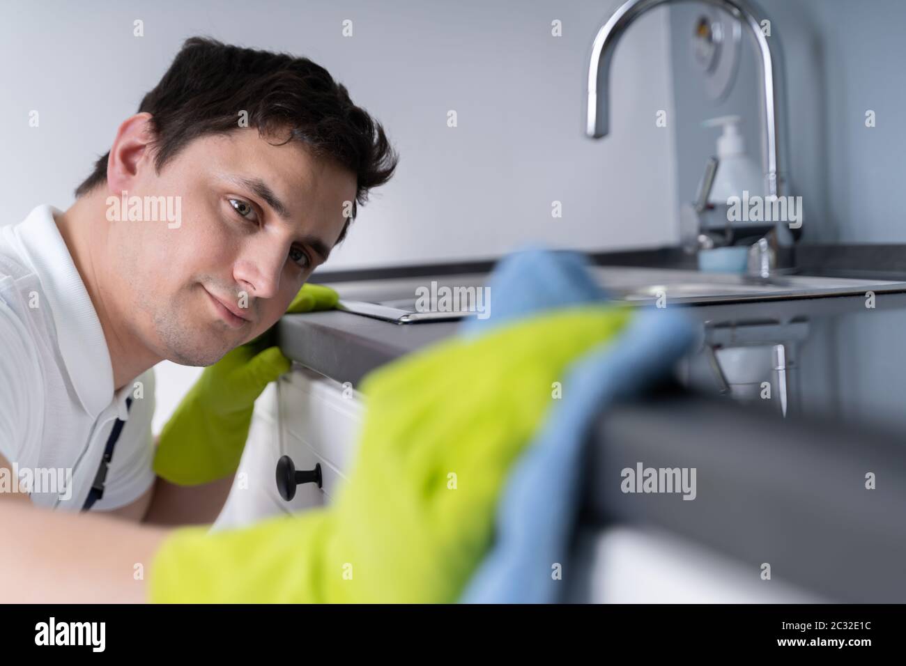 Young man wearing apron cleaning hi-res stock photography and images ...