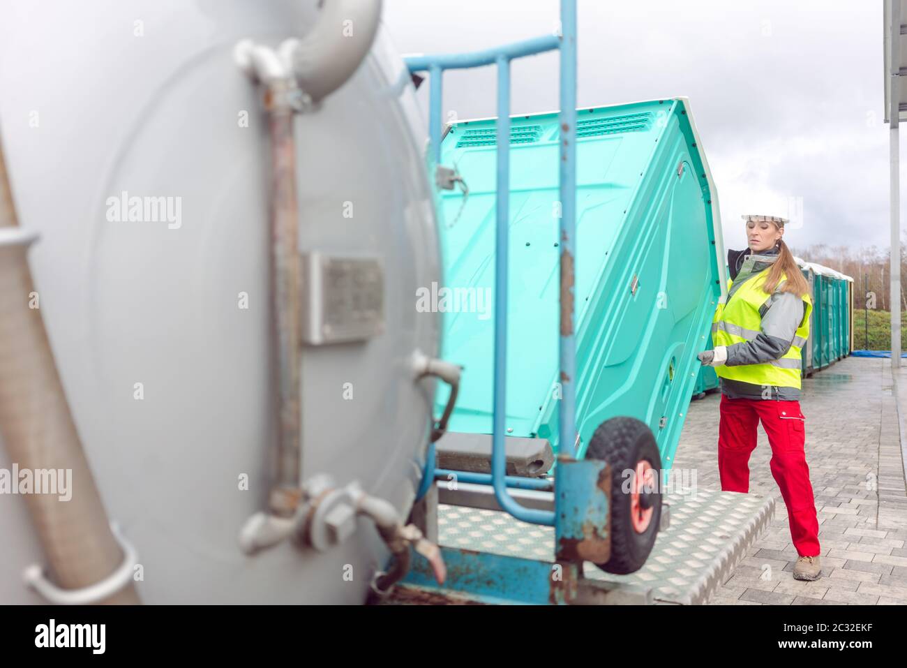 Mobile toilet being loaded on delivery truck by worker Stock Photo - Alamy