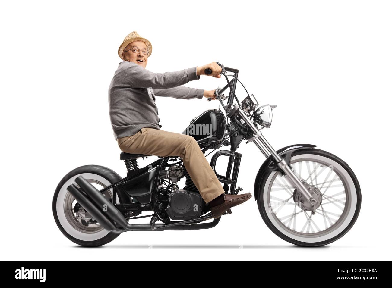 Excited elderly man riding a custom chopper motorbile and looking at ...