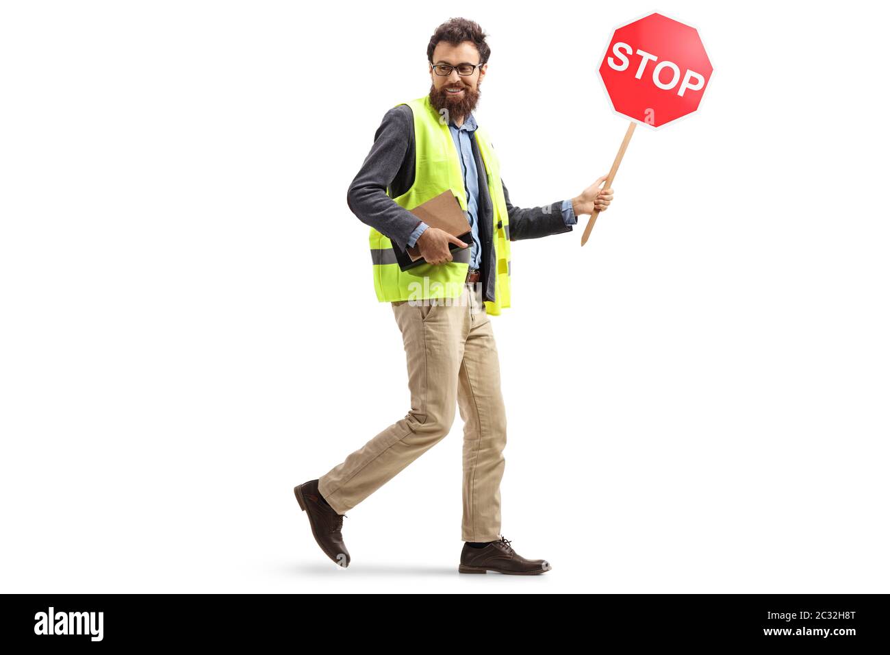 Full length shot of a bearded man in a safety vest walking with a stop ...