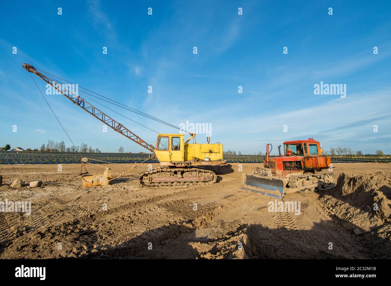 Tractor and excavator stay in the after hard work Stock Photo - Alamy