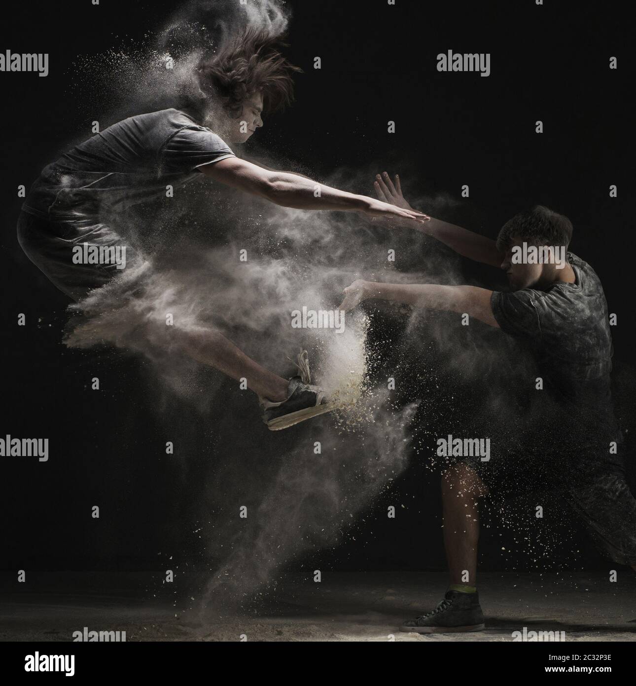 Two male dancers jumping in white dust cloud view Stock Photo - Alamy