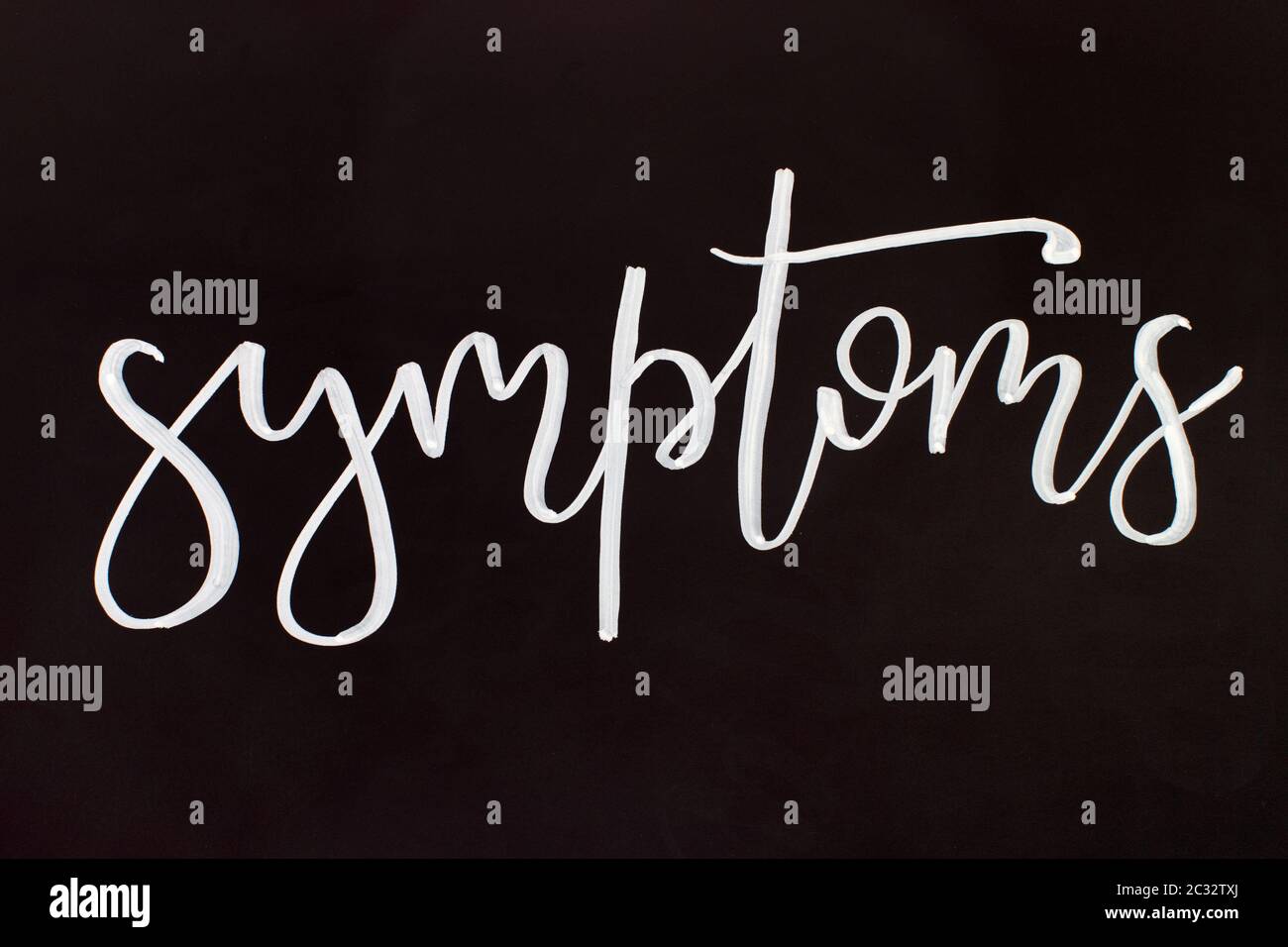 Chalk inscription SYMPTOMS on a black chalkboard. Handwritten lettering ...