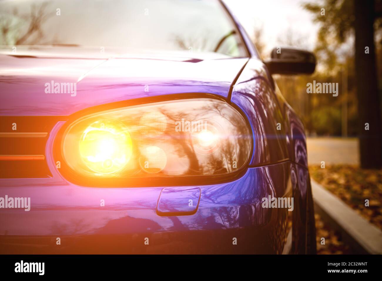 Modified yellow xenon headlights of blue modern car. Lowrider with air ...