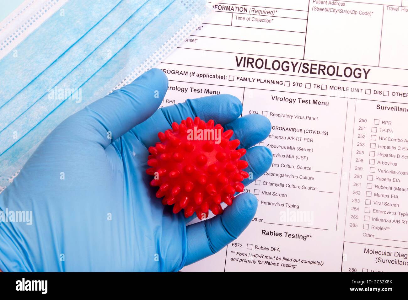 Doctor's hand holding red virus ball concept over a virus test lab ...