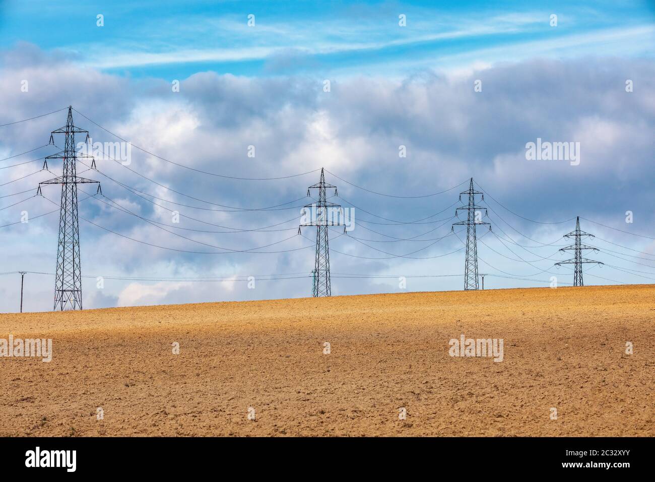 high voltage power lines in field against a blue sky. Europe Czech ...