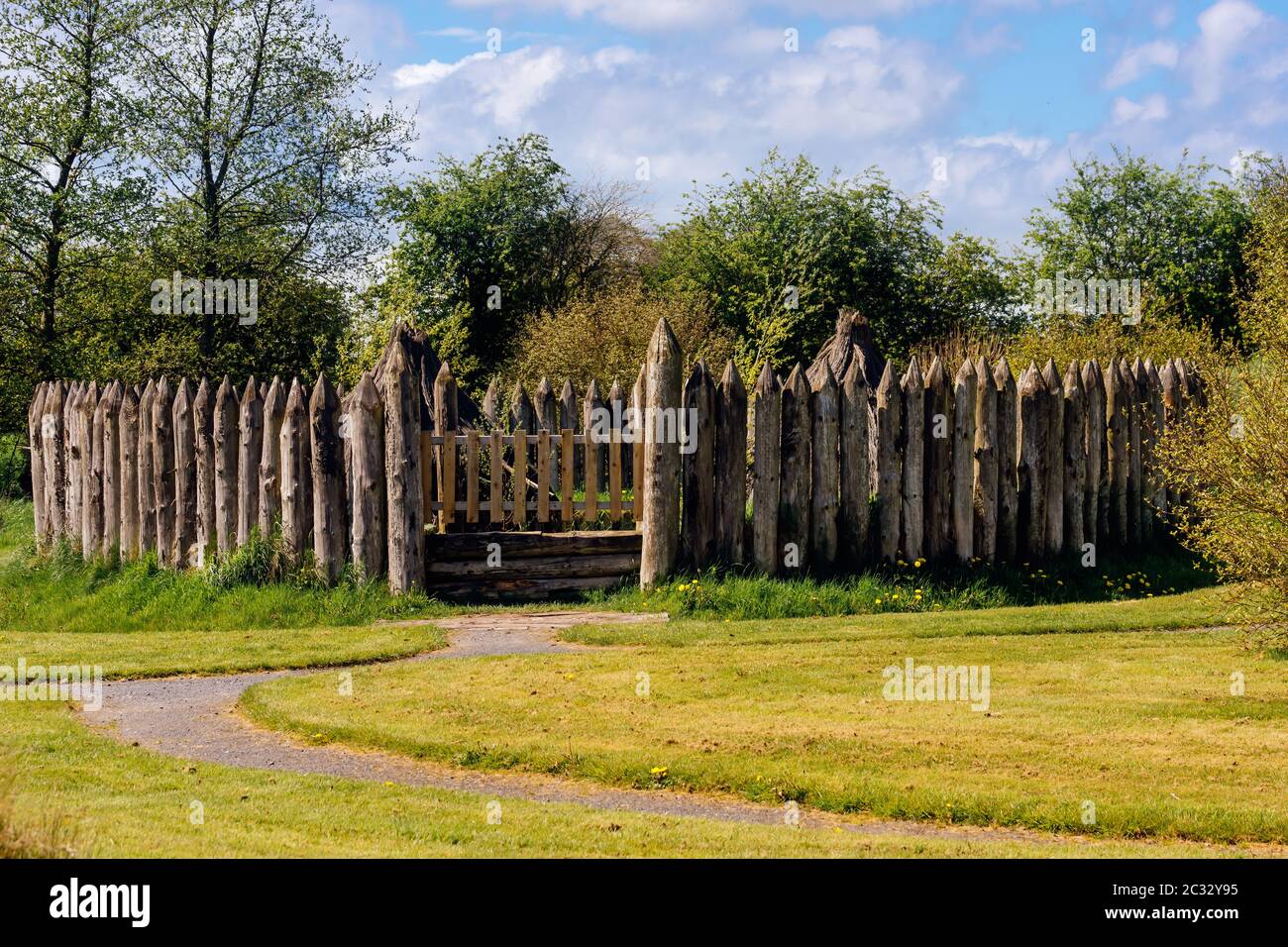 Old wooden palisade of the fort or camp surrounded by green fields and ...