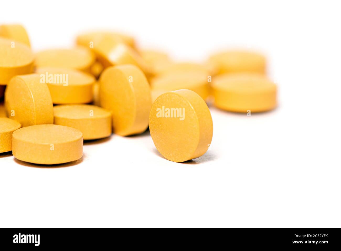 Group of orange pills over a white background Stock Photo - Alamy