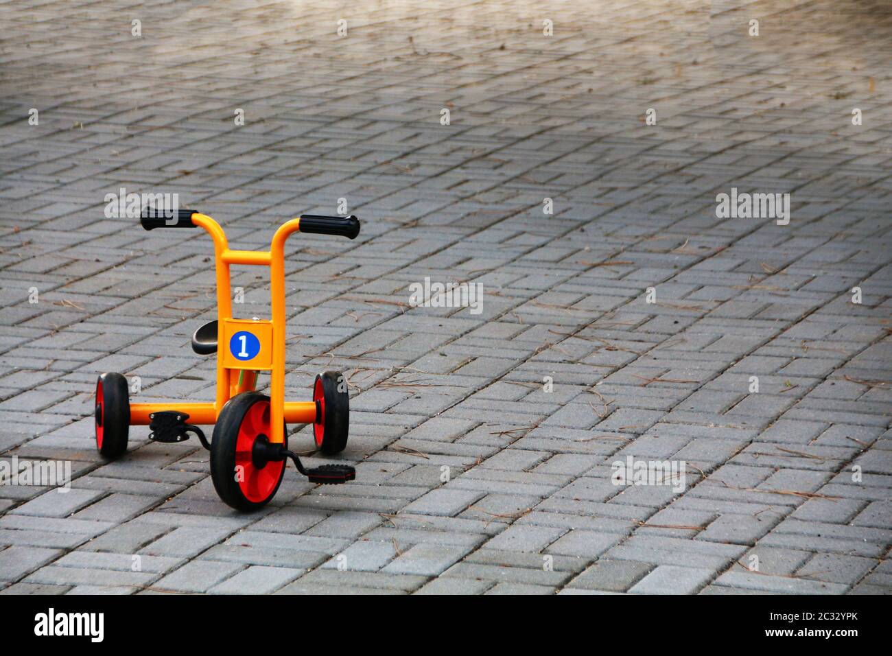 Close up view of a orange playground tricycle Stock Photo - Alamy