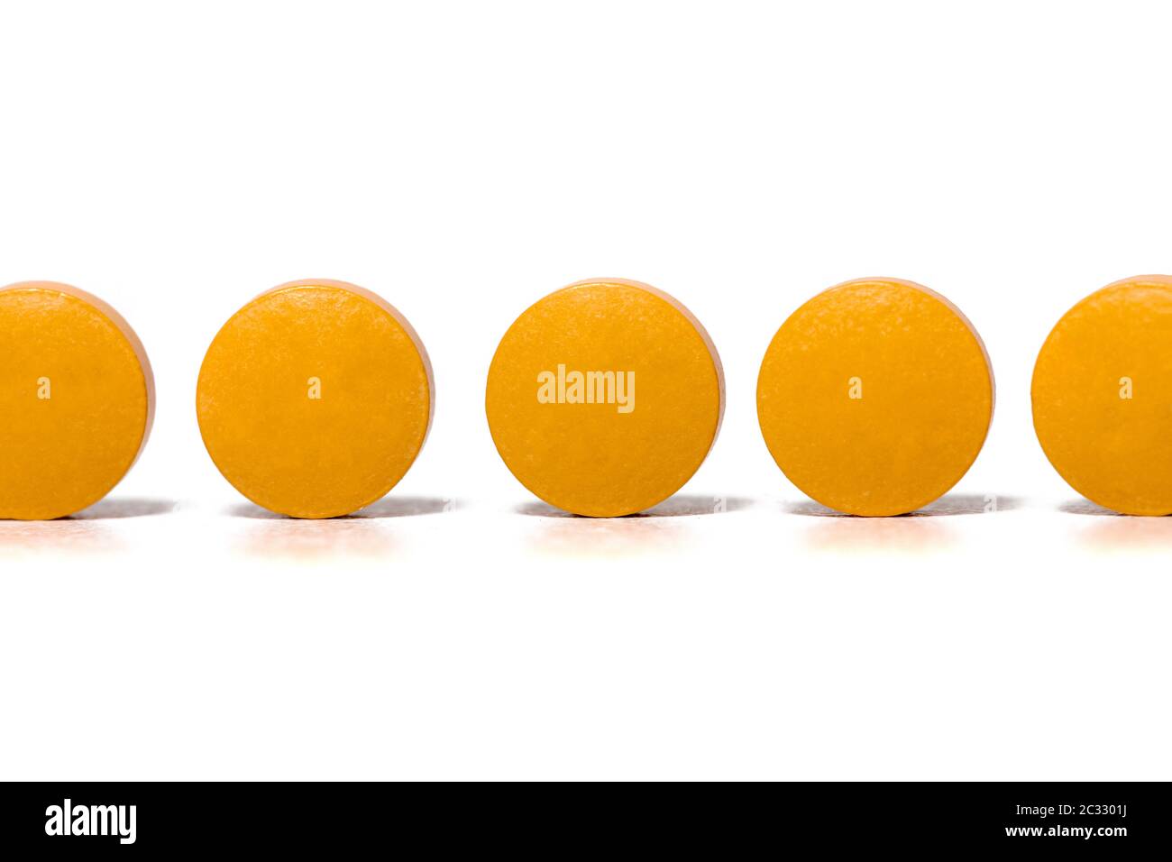 Group of orange pills over a white background Stock Photo - Alamy