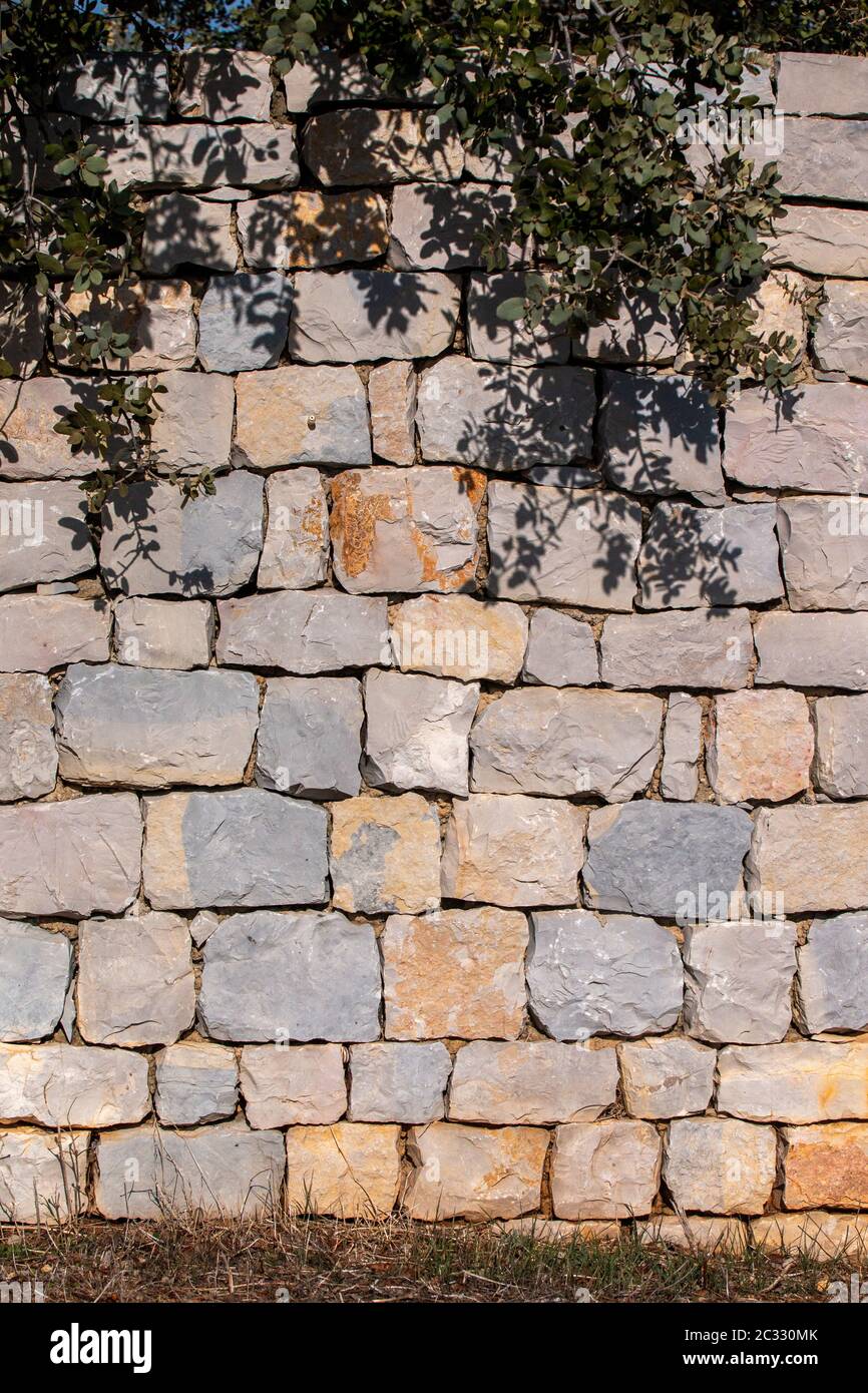 Rural stone wall texture on the sunlight with tree leaves Stock Photo ...