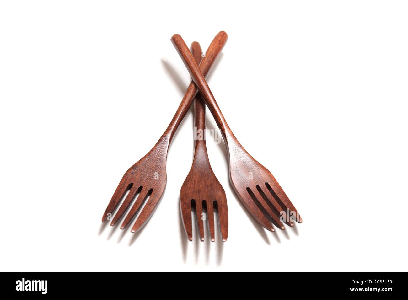 Close view of wooden forks over a white background Stock Photo - Alamy