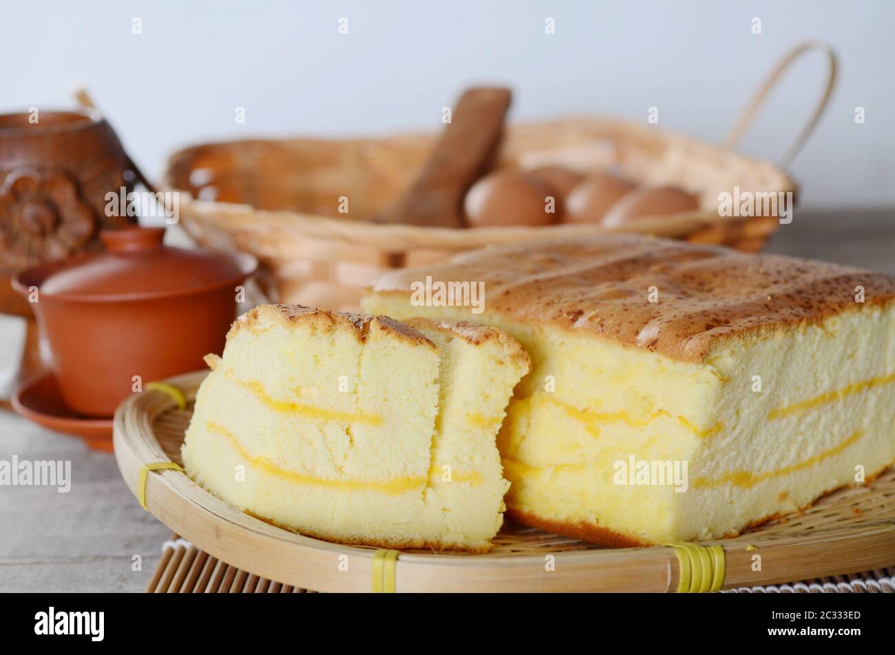 Taiwanese cheese sponge cake with bamboo weaving basket on wooden board ...