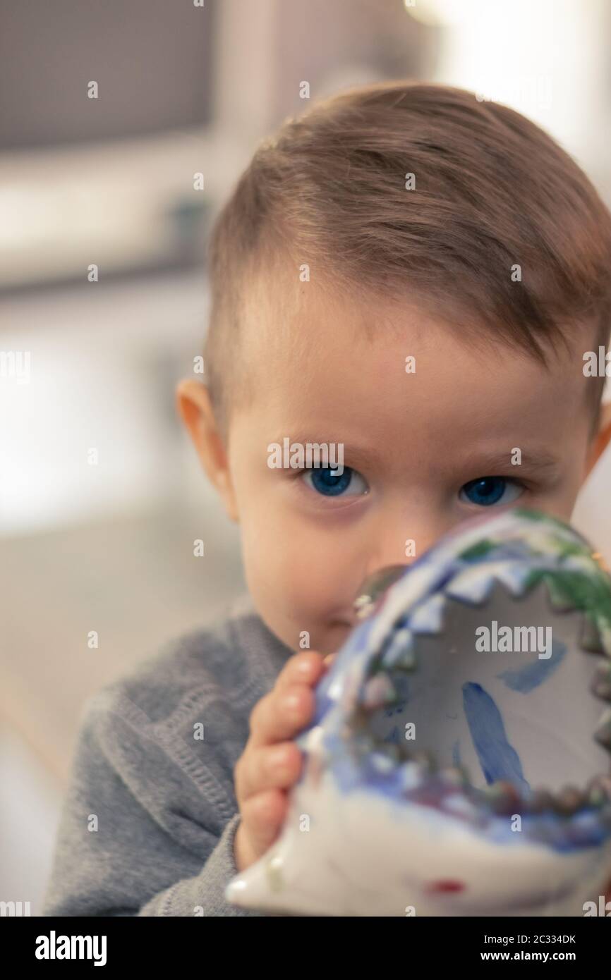 Toddler holding a shark pot with blue eyes Stock Photo - Alamy