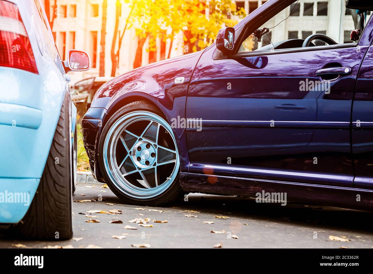 Two modified low cars in purple candy and light blue color. Stance ...