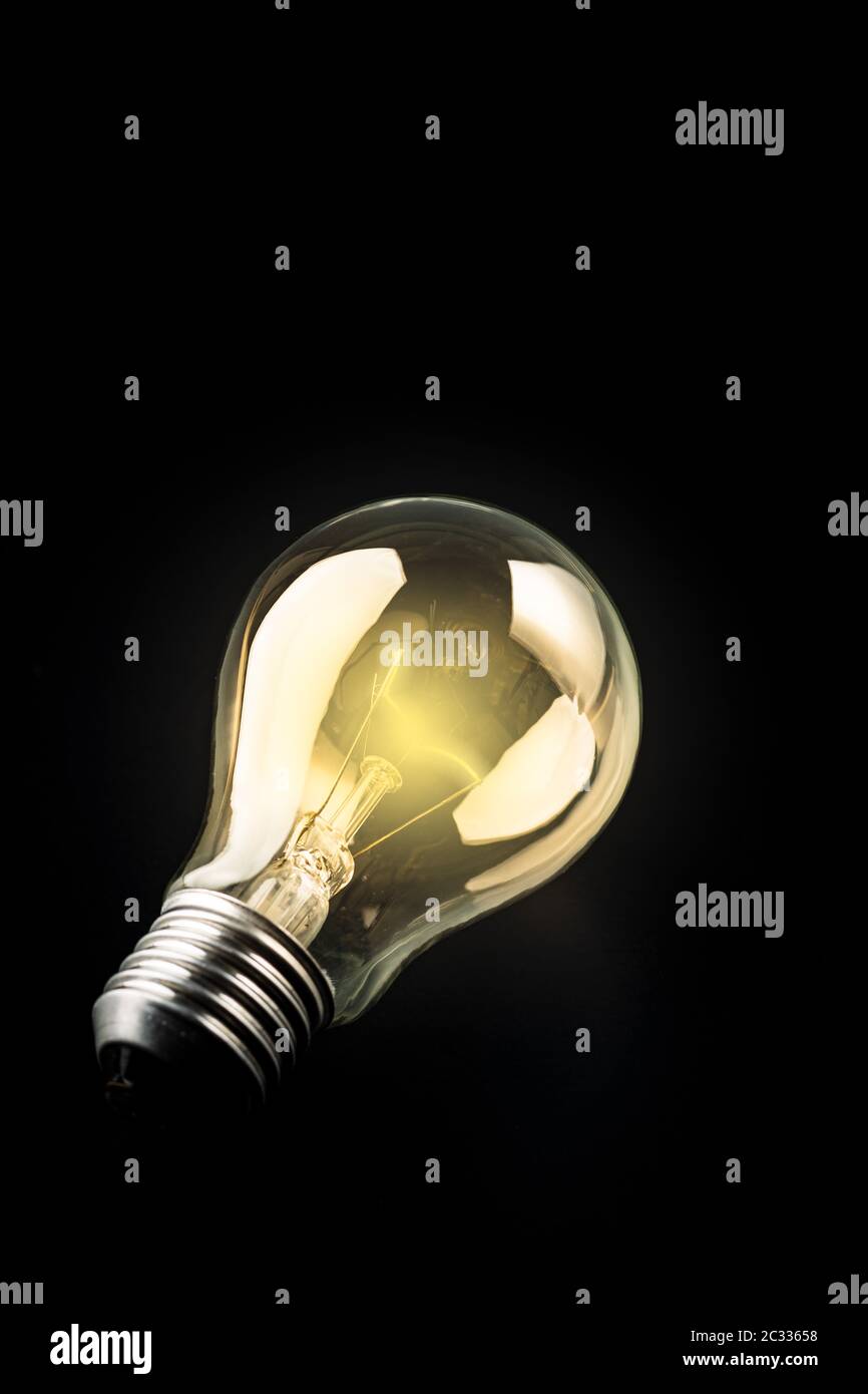 Classic light bulb on black background Stock Photo - Alamy