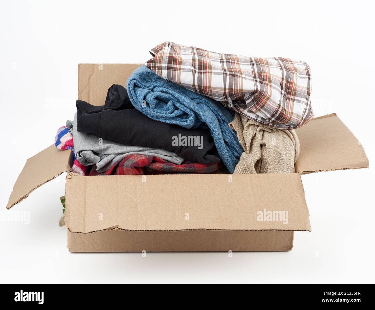 big brown cardboard box filled with various clothes on a white ...