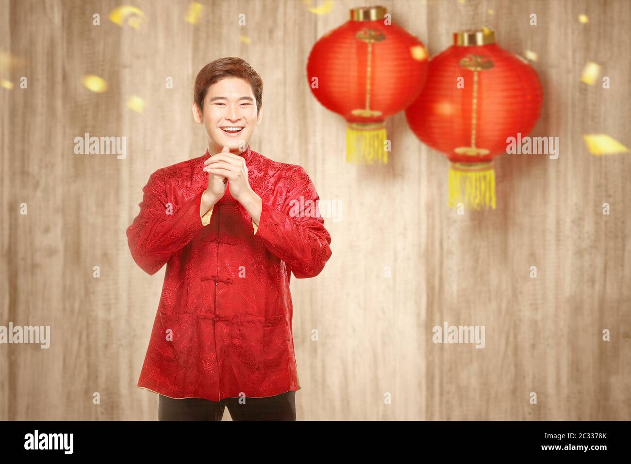 An Asian Chinese man in a cheongsam dress with congratulations gesture ...