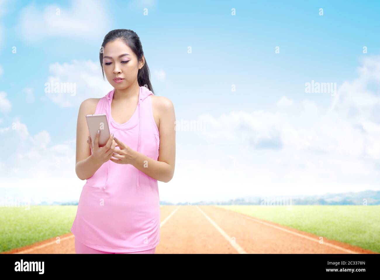 Asian runner woman using a mobile phone at the break after running on ...