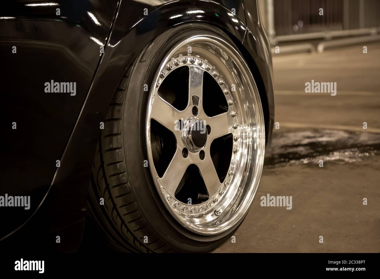 Alloy polished rims of a sports car. Wide wheels with stretched tires ...