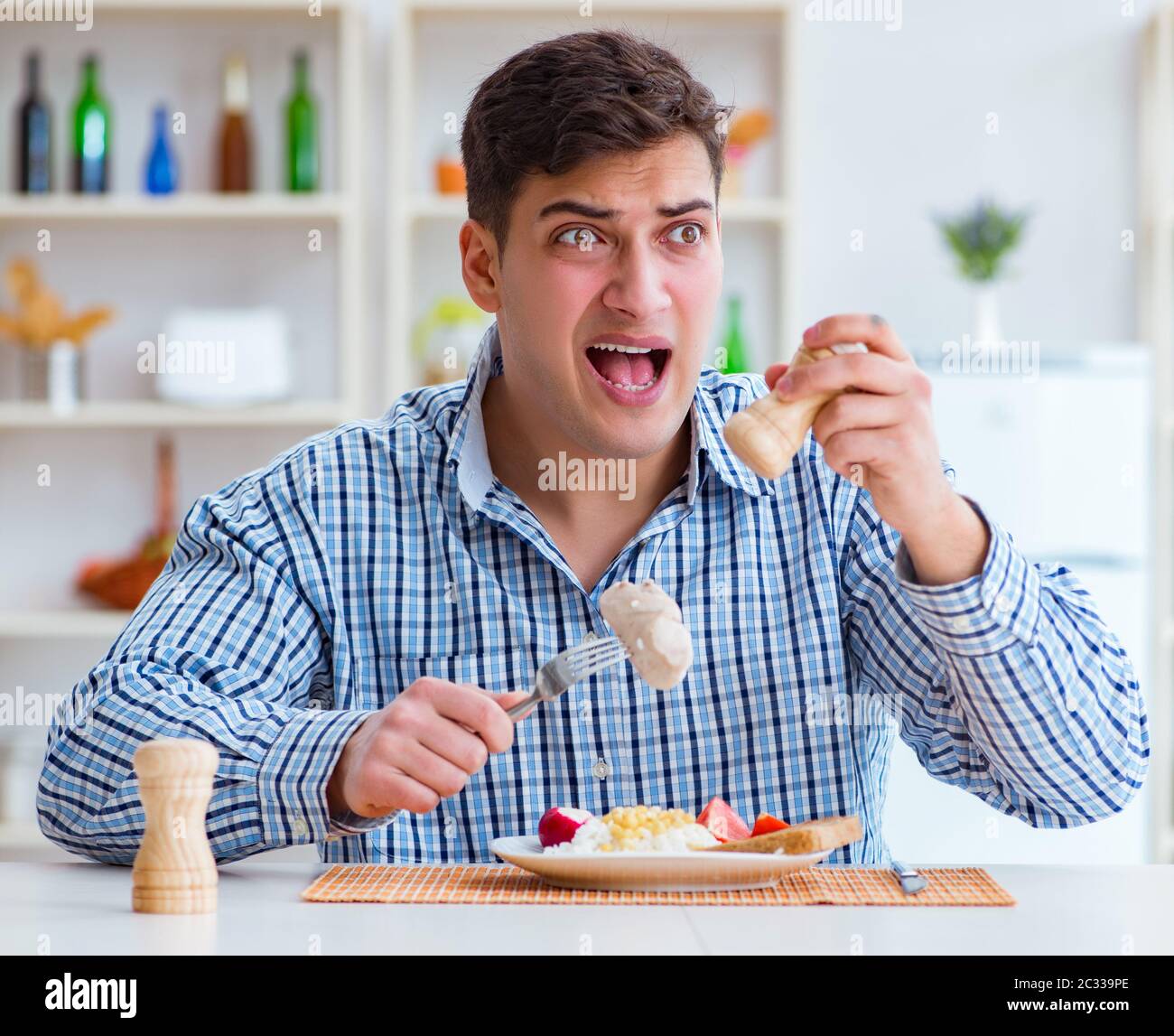 Man eating tasteless food at home for lunch Stock Photo - Alamy