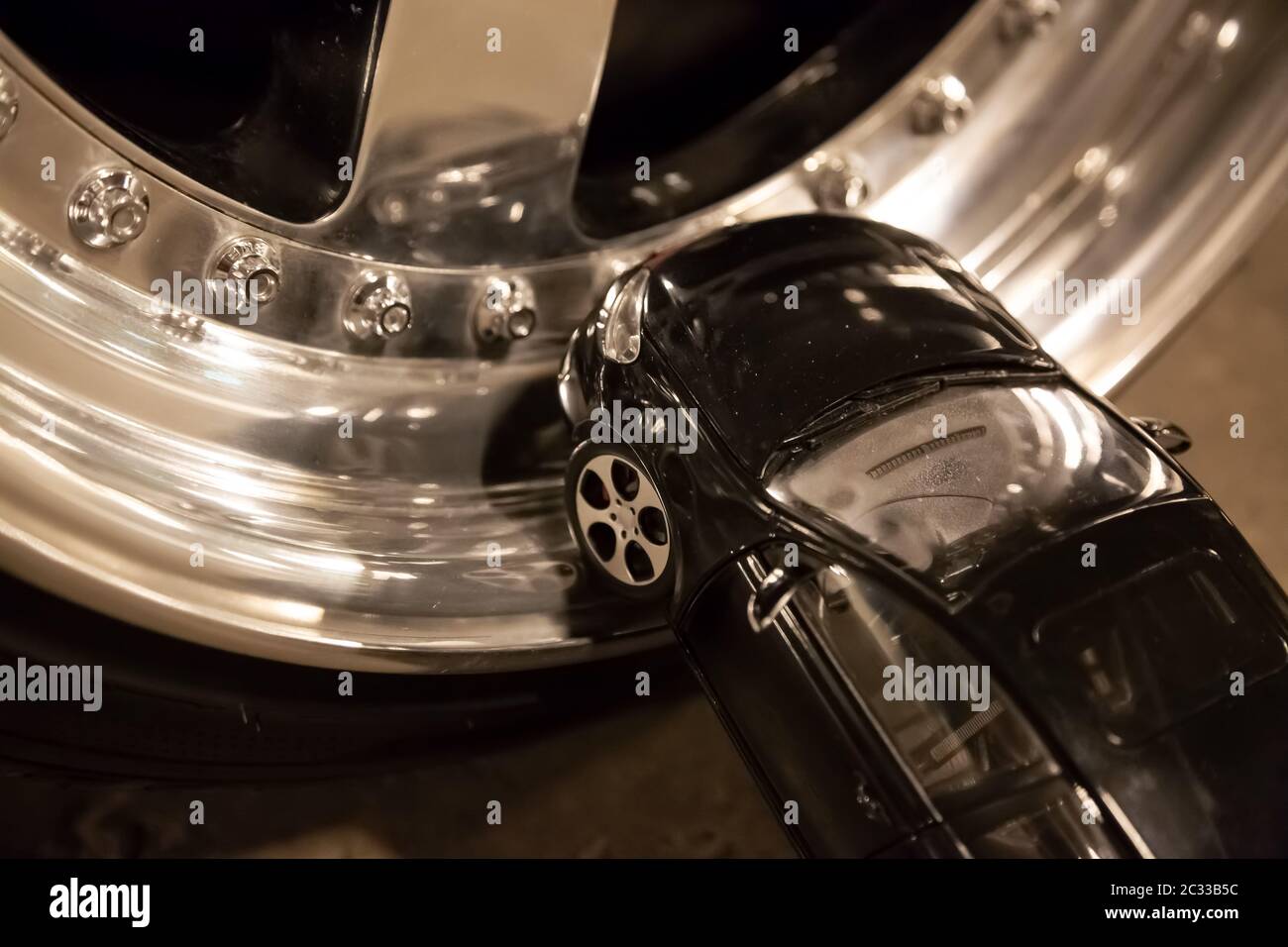 Black toy car stays on alloy rims of real car. Custom tuning wheels ...