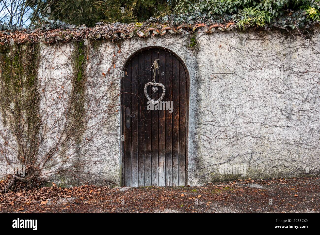 Old wooden door in a long stone wall Stock Photo - Alamy