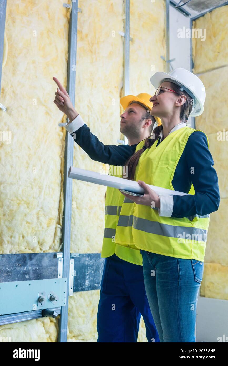 Construction manager and architect checking the insulation works in a ...