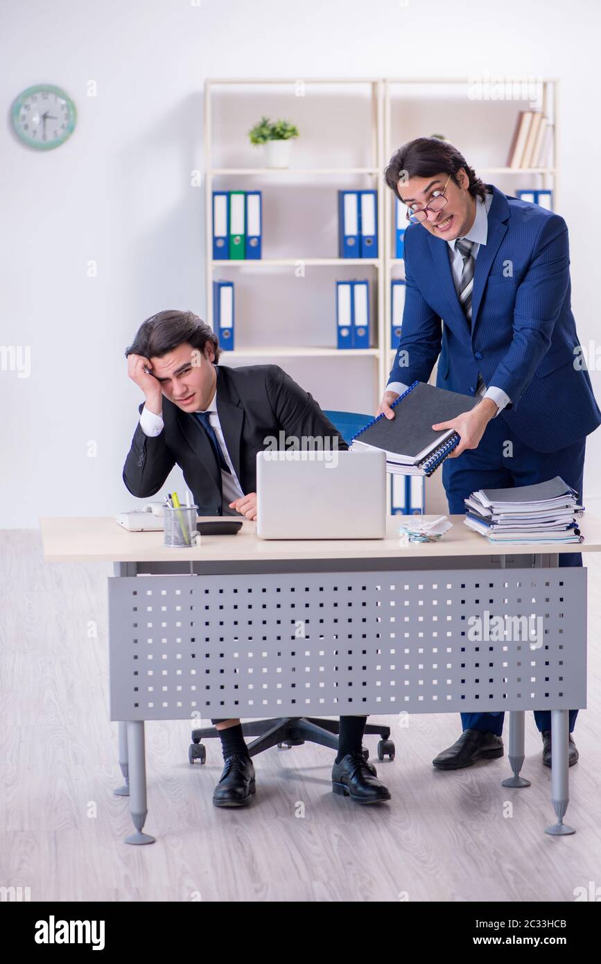 Boss and his male assistant working in the office Stock Photo - Alamy