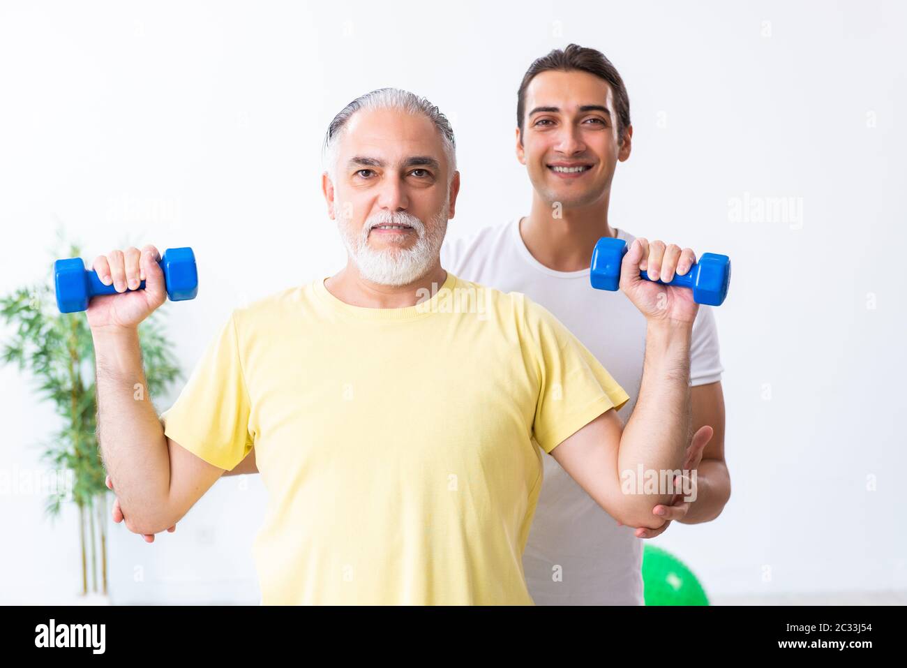 Old man doing exercises indoors Stock Photo - Alamy