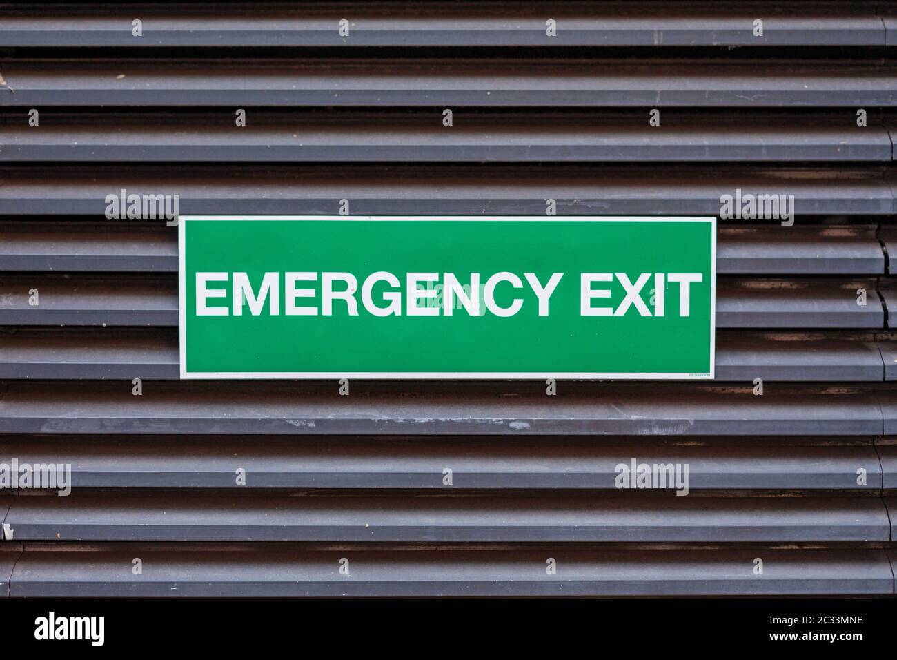 Green Sign Emergency Exit at Building Door Stock Photo - Alamy