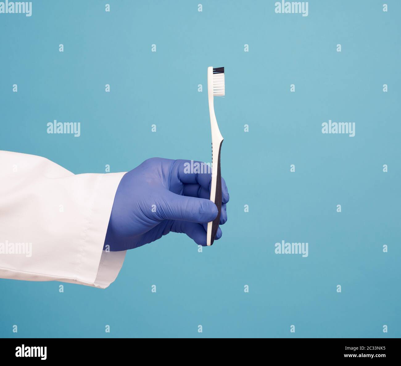 doctor in a white robe uniform and blue sterile gloves holding a ...