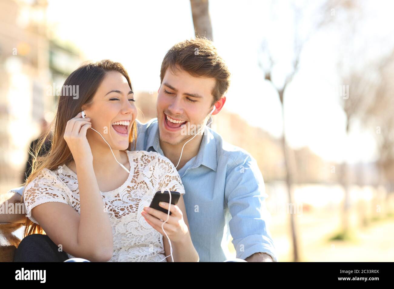 Couple sharing earbuds hi-res stock photography and images - Alamy