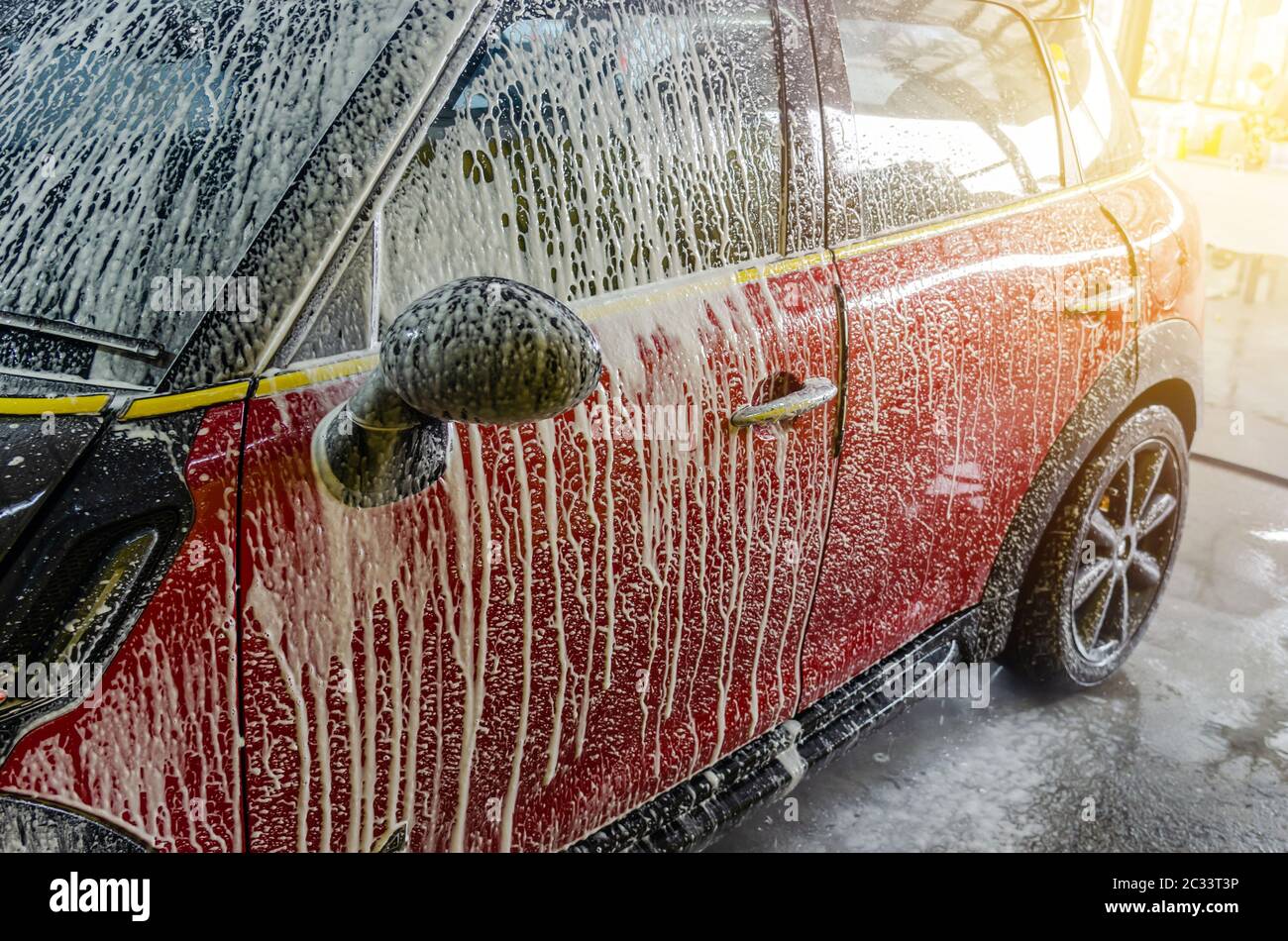 Cleaning red cars. Wash the car at the car wash station with foam ...