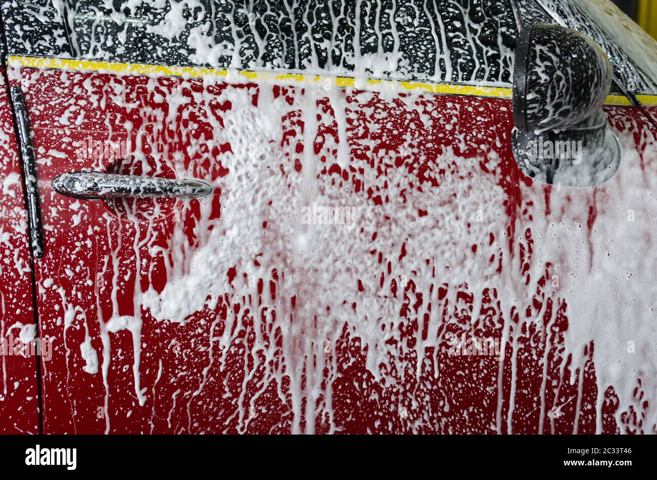 Cleaning red cars. Wash the car at the car wash station with foam ...