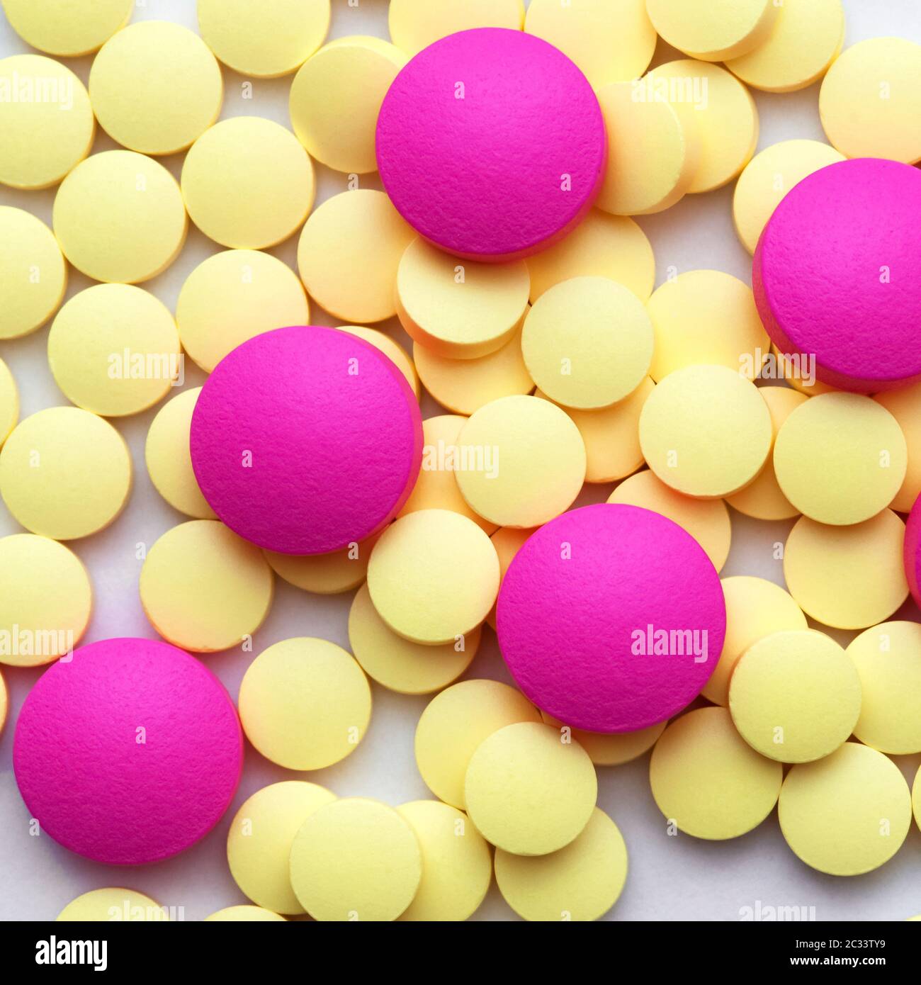 Yellow and pink pills on a white background Stock Photo - Alamy