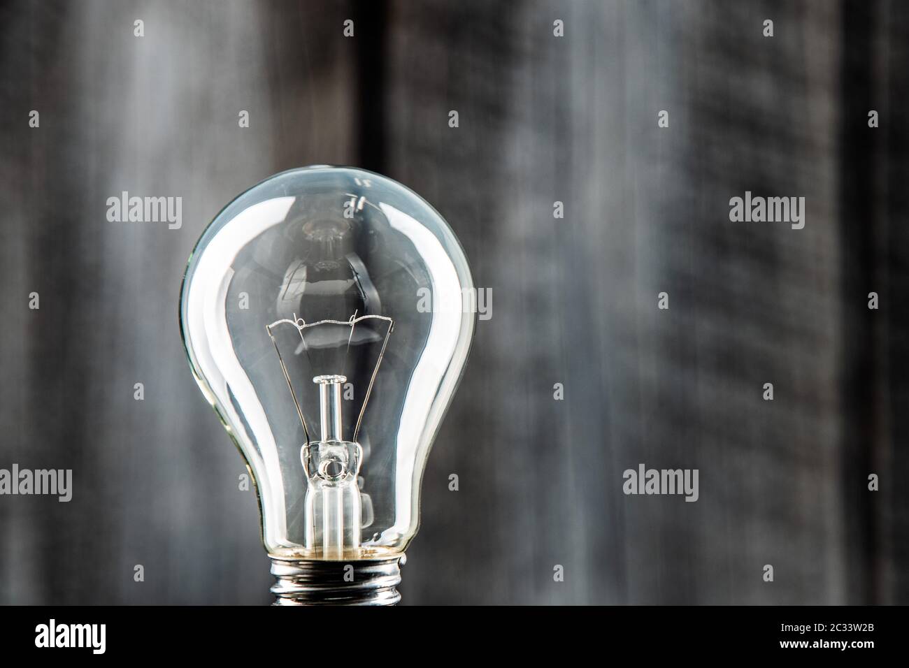 Classic light bulb on front of rustical wall Stock Photo - Alamy