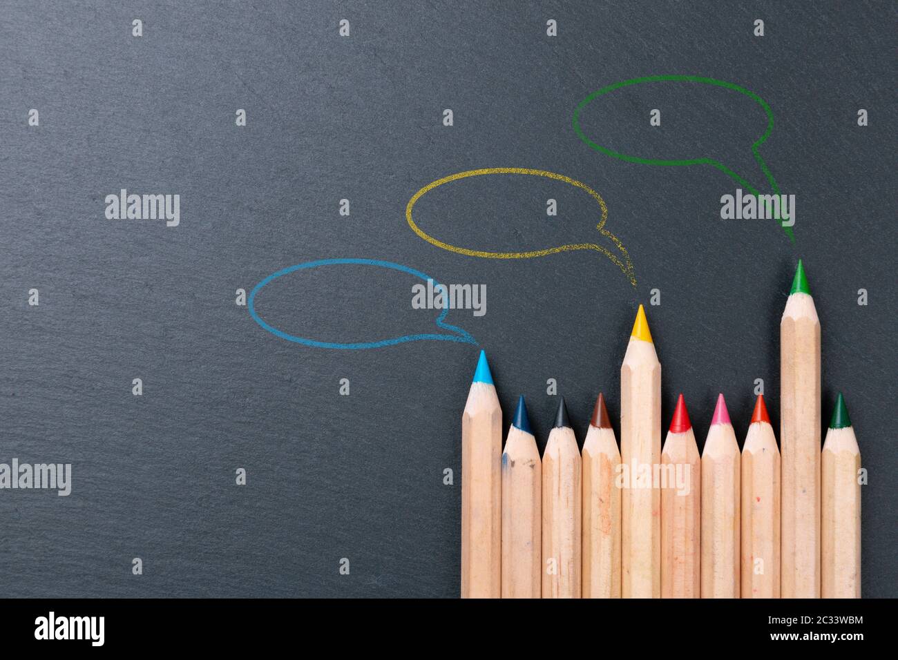 Colored pencils with three speech bubbles above. Chalkboard background ...