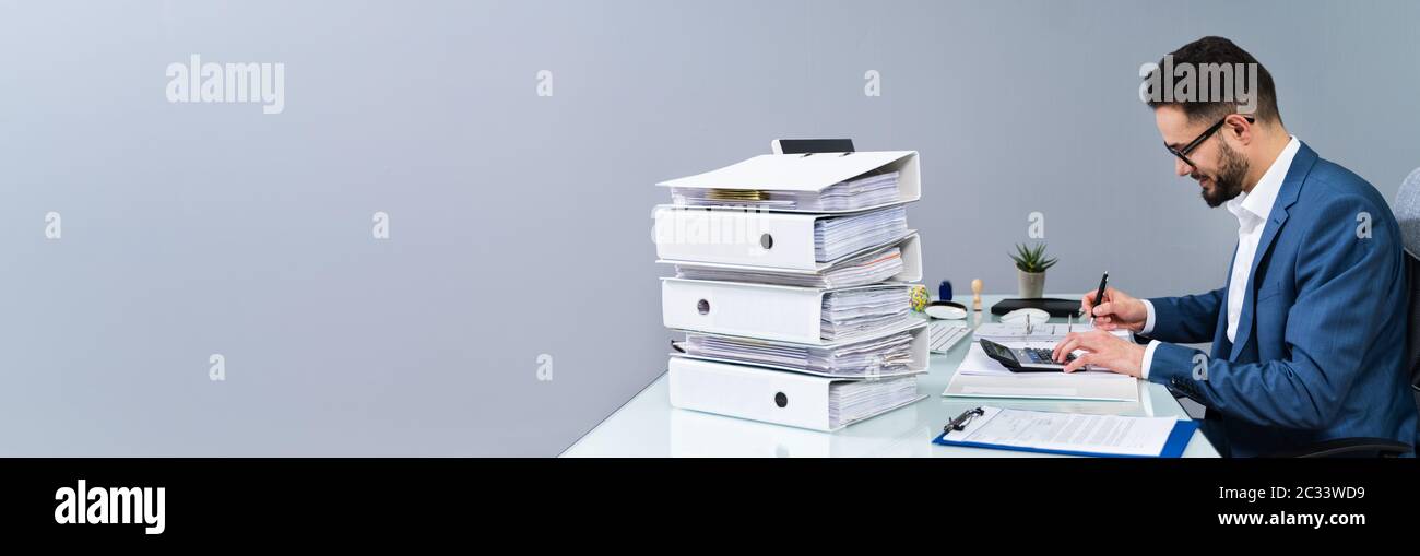 Accountant Making Invoice On Computer At Desk Stock Photo - Alamy