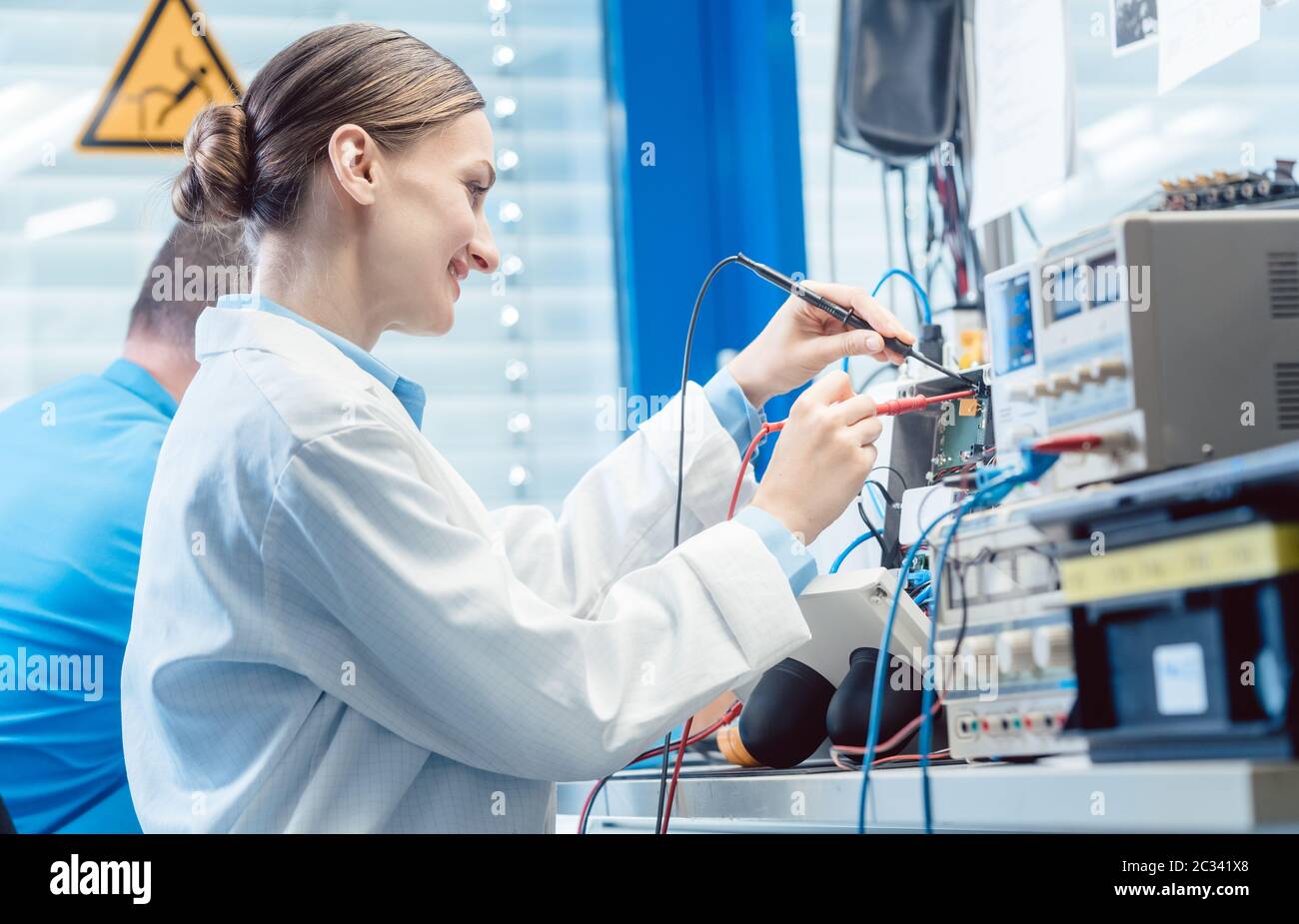 Team of engineers, woman and man, testing and measuring an electronic ...