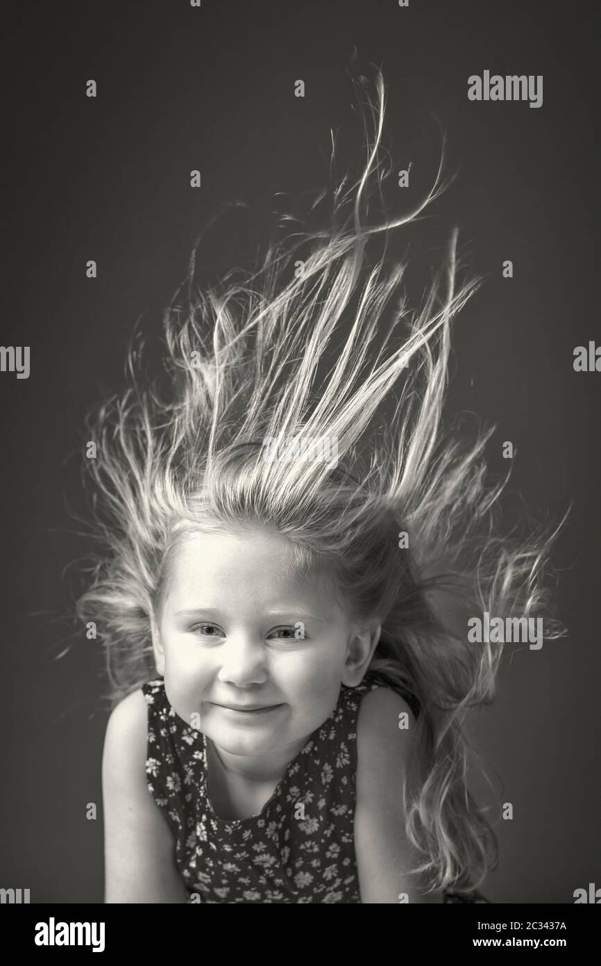 studio portrait of a 3 year old Caucasian girl with her hair raised in ...