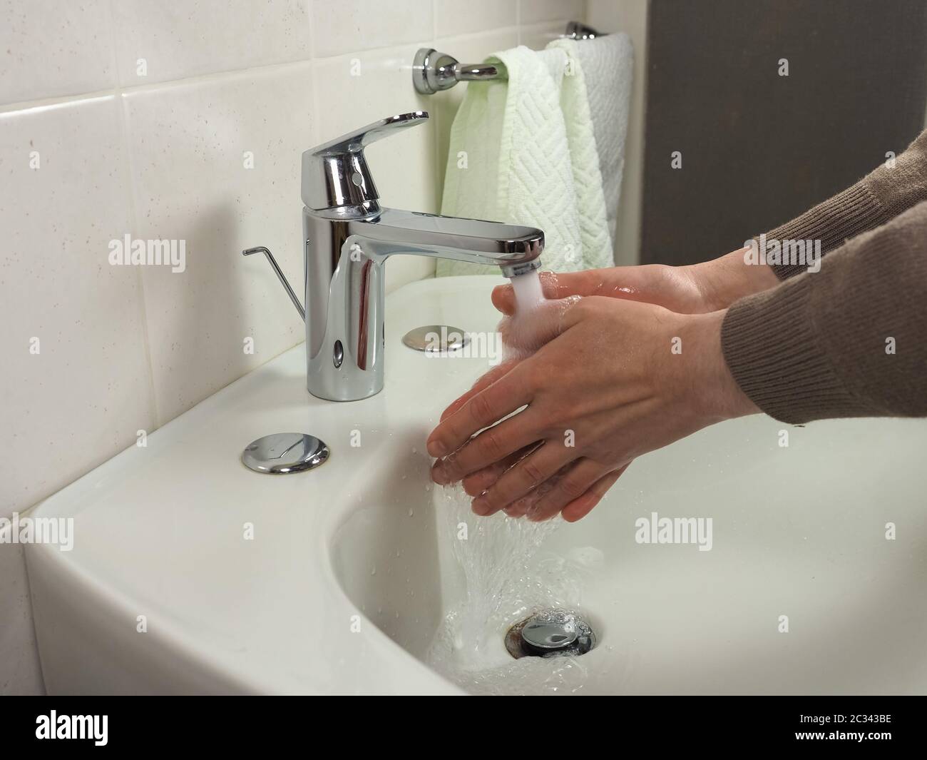 Unrecognisable man carefully washing hands at home for health safety ...