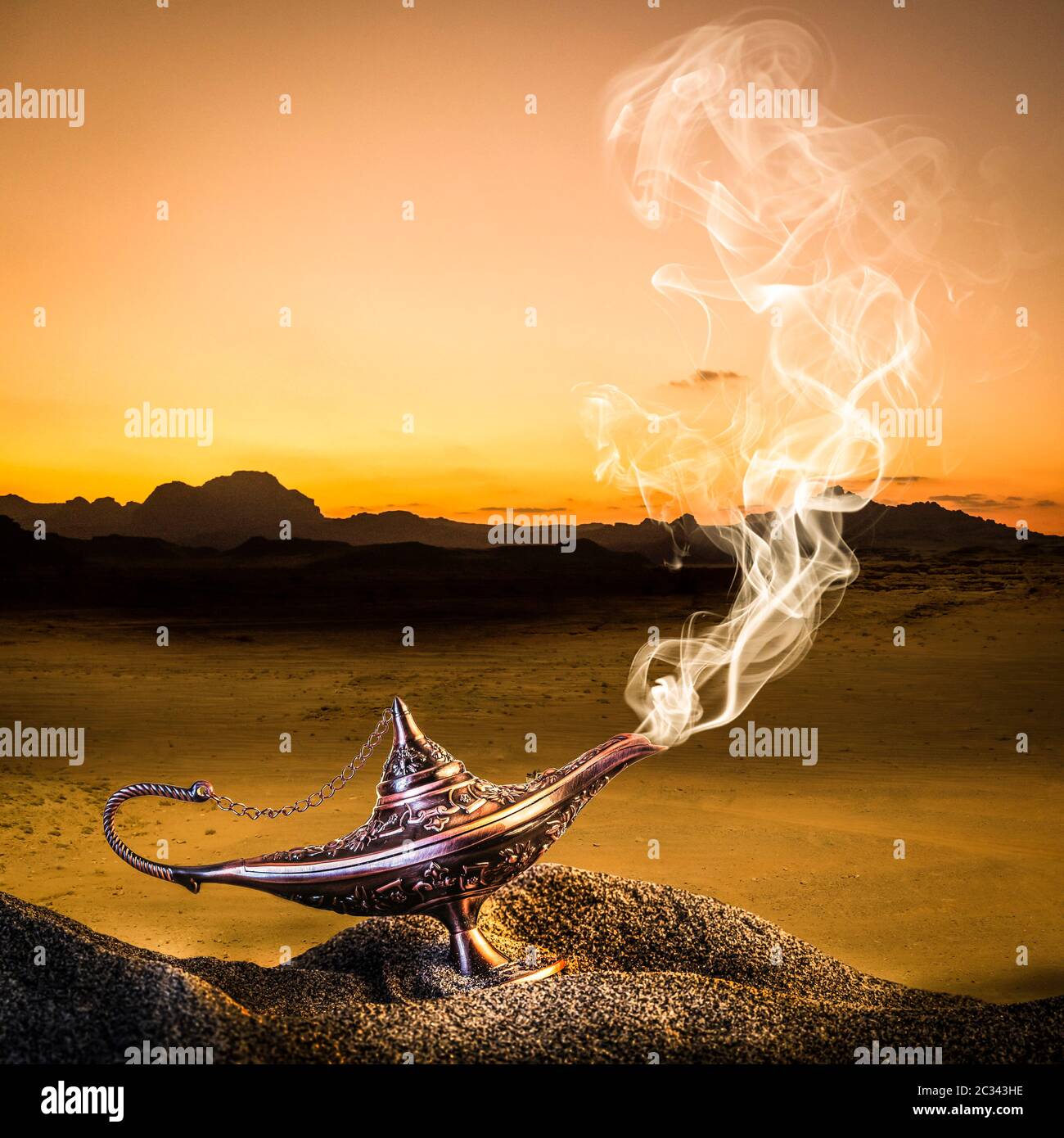 classic gold-colored aladdin lamp laid on the sand of a dune with smoke ...
