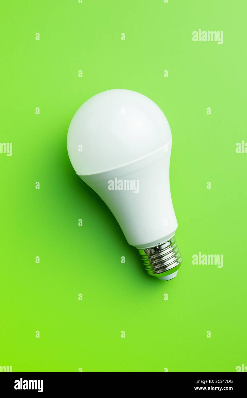 Energy saving light bulb on green background. LED light bulb. Top view ...