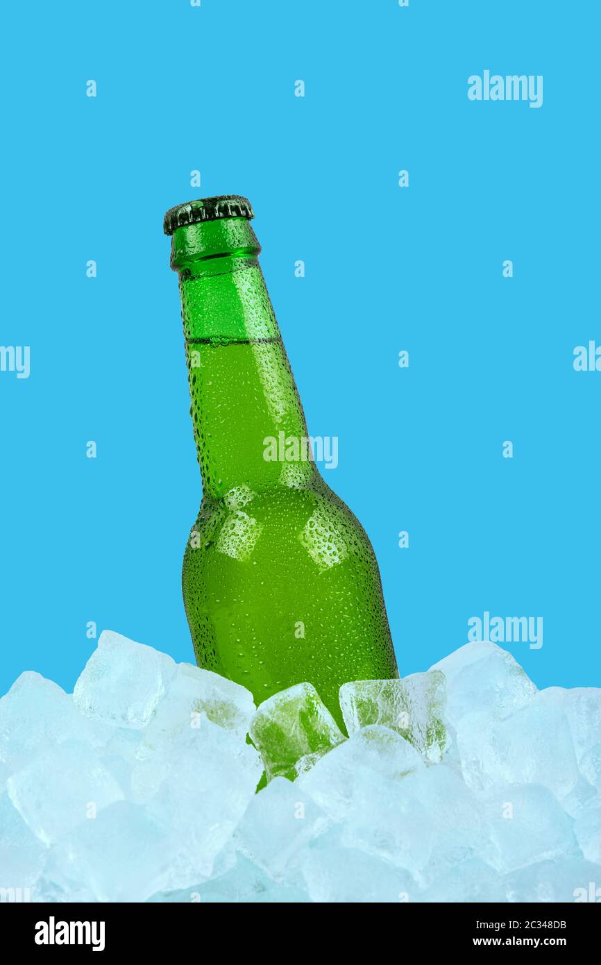 Close up one green glass bottle of cold lager beer on ice cubes at ...