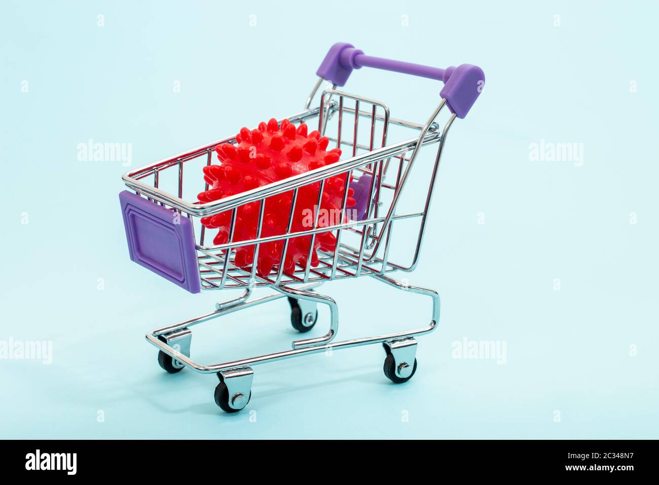 Virus in a miniature shopping cart isolated on a light blue background ...