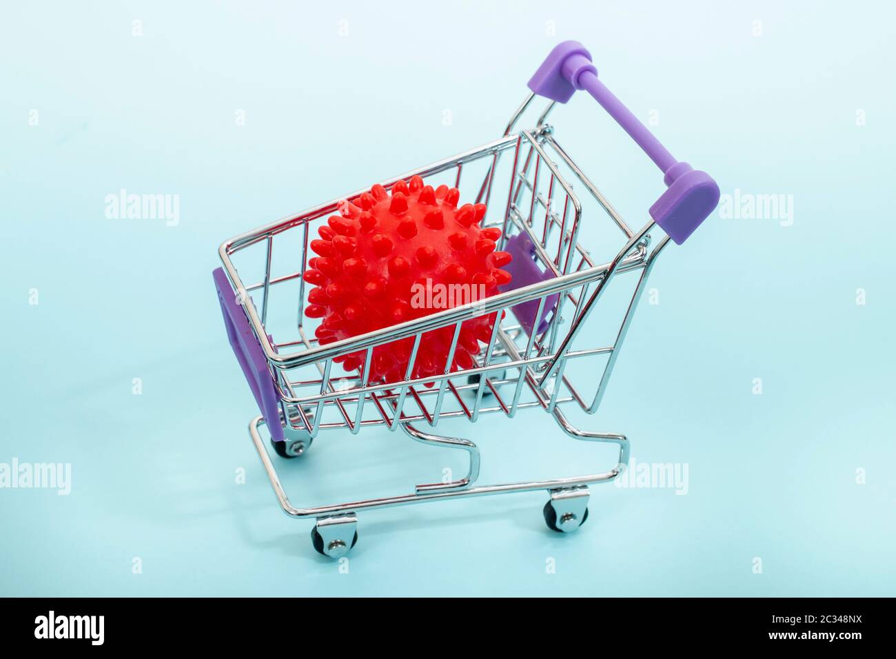 Virus in a miniature shopping cart isolated on a light blue background ...