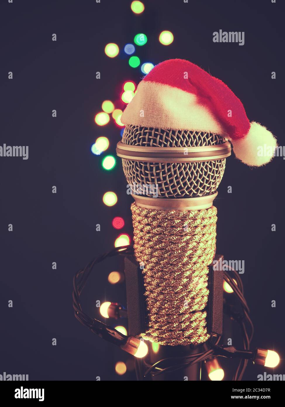 Close up of a microphone with the hat of Santa on a dark studio ...