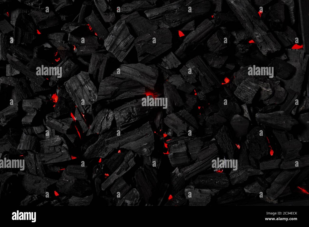 Black coal background illuminated with red light like fire underneath ...