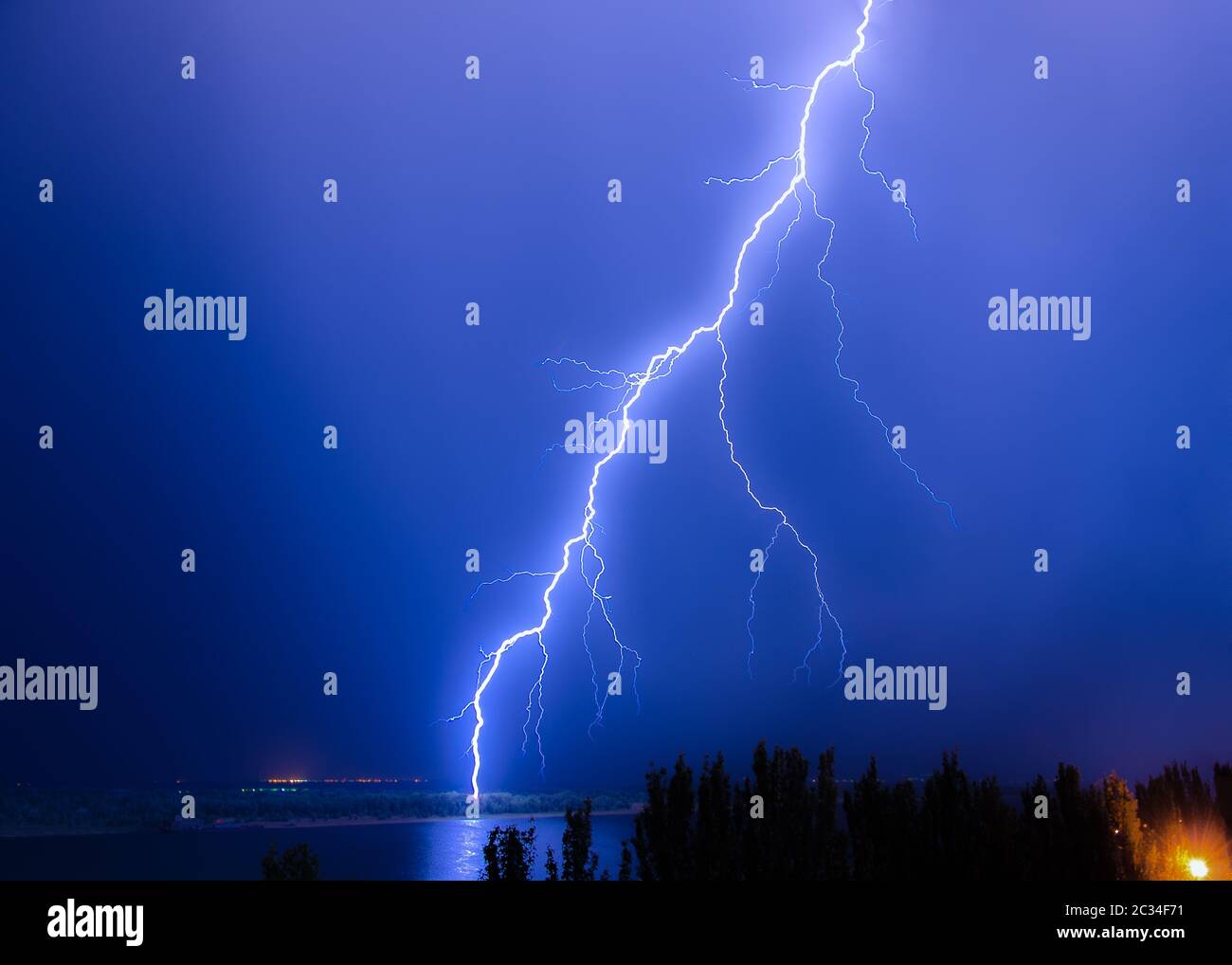 Lightning strike in the night sky above the river Stock Photo - Alamy